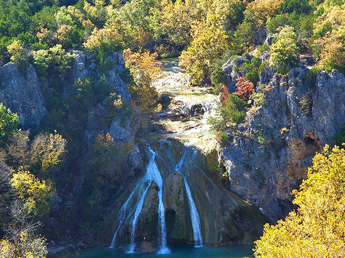Nature's grand reveal: Turner Falls cascades 77 feet into a turquoise pool that looks like someone smuggled a piece of the Caribbean into Oklahoma. 