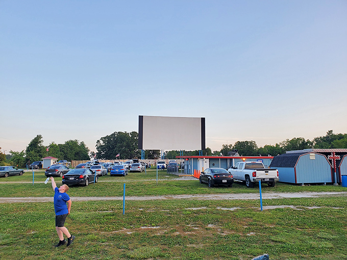 Cars aligned in perfect movie-watching formation as dusk approaches. Some visitors come early to claim prime viewing spots with blankets and lawn chairs.