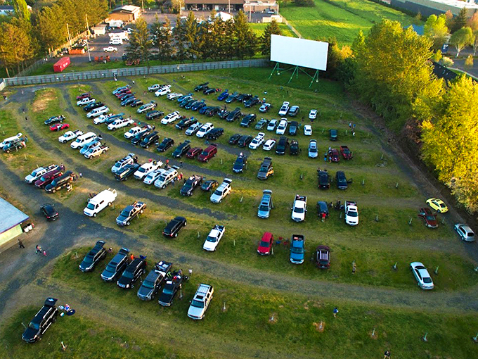 As twilight descends, cars line up facing the massive white screen, where cinematic dreams come alive under Oregon's star-studded sky. 