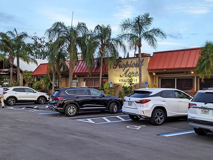 Tropical Acres stands like a time-honored oasis amid swaying palms, its iconic red roof and yellow walls promising culinary treasures within.