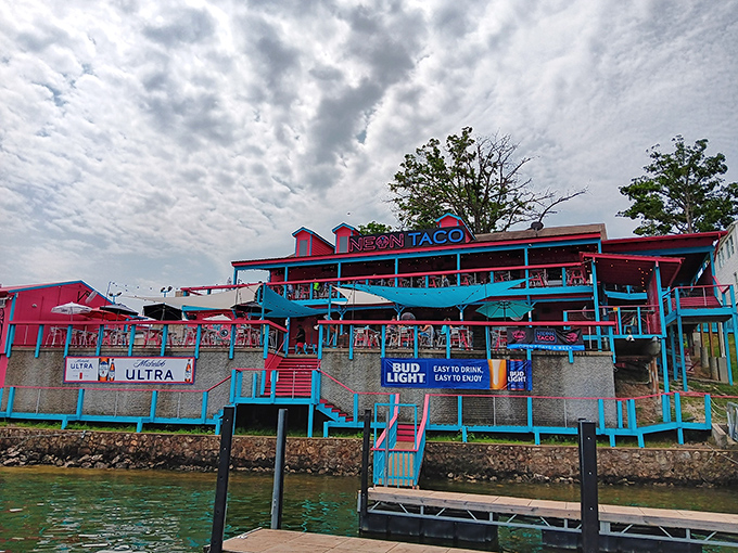 The neon dream beckons from the shoreline, a pink and turquoise beacon promising coastal flavors in the heart of Missouri's lake country.