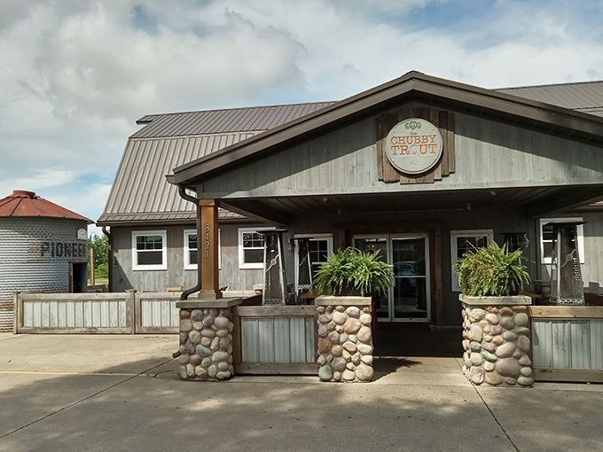 The barn-like facade of The Chubby Trout stands proud with its distinctive silo structure and weathered gray exterior. Rustic charm meets culinary adventure in this unassuming roadside treasure.