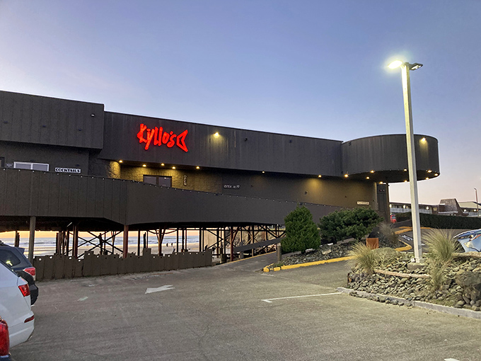Kyllo's distinctive exterior stands like a modern lighthouse above the beach, beckoning hungry travelers with its glowing red sign.