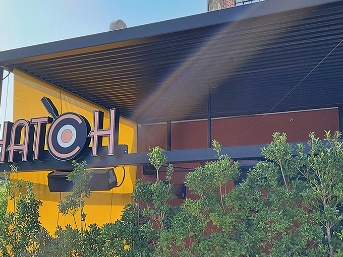 The golden glow of Hatch's signage beckons like a breakfast lighthouse. Those blue chairs aren't just seating&mdash;they're your front-row tickets to the morning's main event.