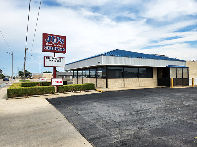 The unassuming blue-roofed building with its simple red sign might not scream "culinary destination," but locals know better. This modest exterior houses Kansas fried chicken royalty.