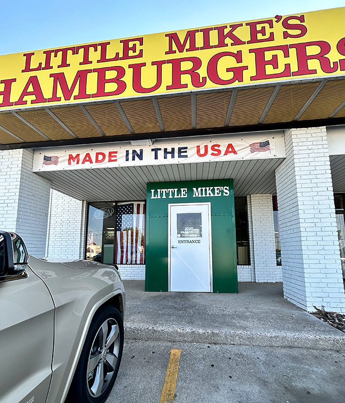The bright yellow sign beckons like a burger lighthouse on the Oklahoma horizon. Nothing says "American classic" quite like that patriotic banner.