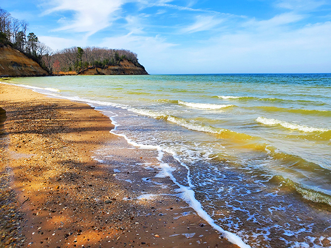 Nature's own sculpture gallery where towering cliffs meet gentle waves, creating a beach experience that's part geological wonder, part treasure hunt.