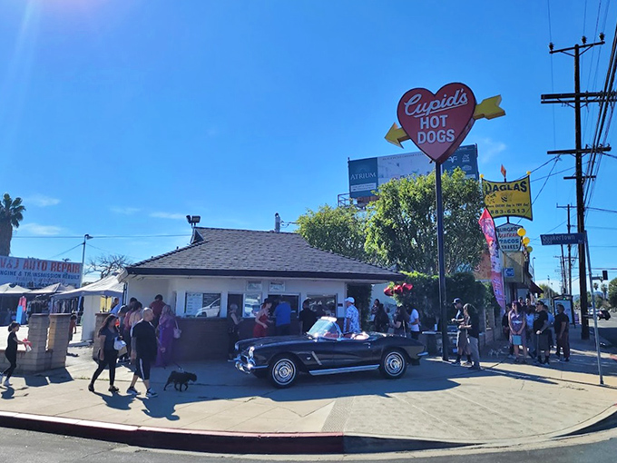 The iconic heart-shaped sign beckons hungry travelers like a culinary lighthouse. Cupid's modest exterior hides world-class hot dog magic within.