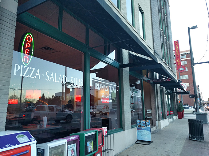 The unassuming storefront of Iriana's Pizza stands like a beacon of hope for hungry downtown Little Rock wanderers. Simple green frames, bold red sign—pizza paradise awaits.