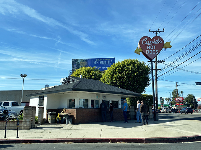 The iconic heart-shaped sign beckons hungry travelers like a culinary lighthouse. Cupid's modest exterior hides world-class hot dog magic within.