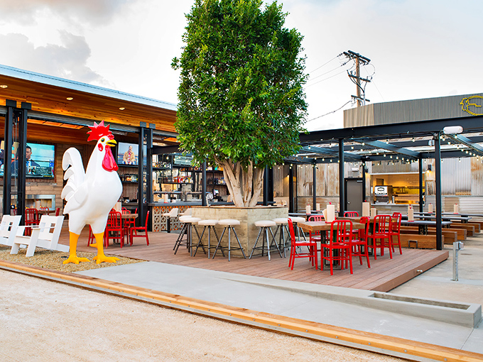 The giant rooster statue stands guard like a poultry bouncer, welcoming hungry pilgrims to this open-air temple of fried chicken perfection.