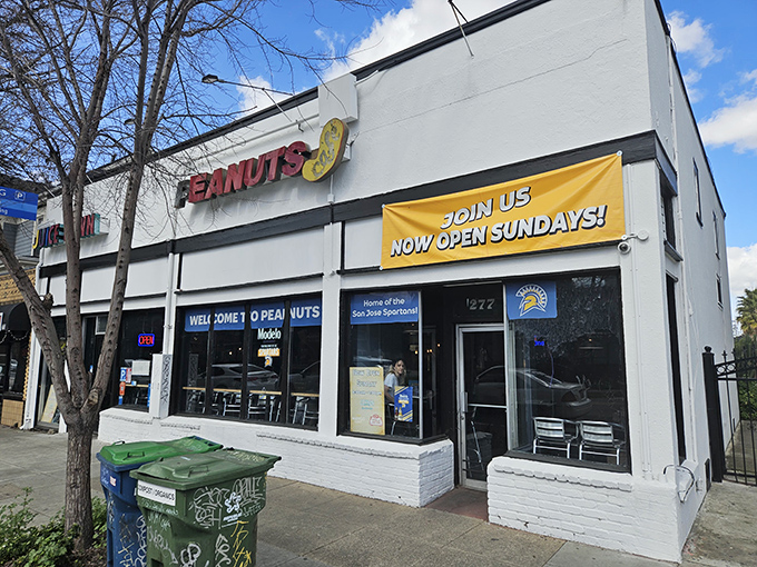 The unassuming white exterior of Peanuts Deluxe Cafe stands like a culinary lighthouse in San Jose, beckoning hungry locals with its bright red signage.