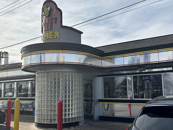 The classic mid-century diner silhouette of Honey Bee stands proud against the Maryland sky, its cheerful bee mascot promising sweet culinary delights within.