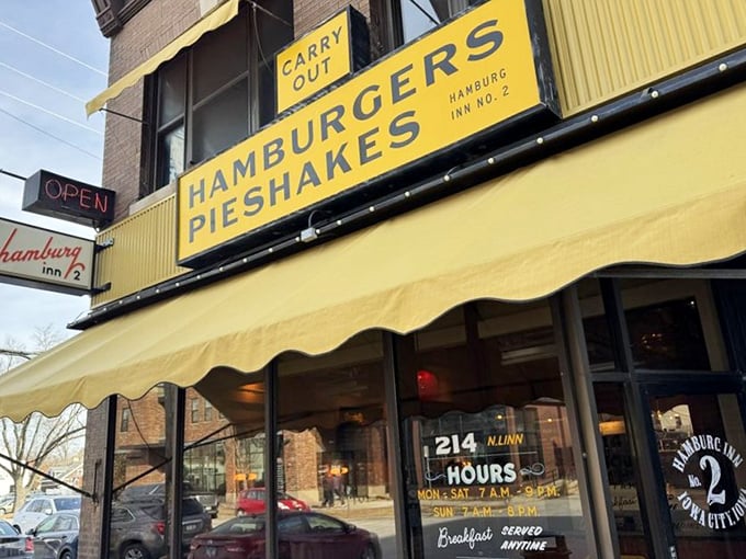 That iconic yellow awning boldly proclaiming "HAMBURGERS PIESHAKES" is like a beacon of comfort food hope on an Iowa City street corner.