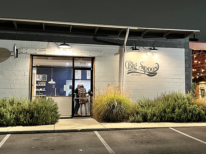 Big Spoon Creamery's white-brick exterior glows like a beacon of dairy-based hope after dark, promising sweet relief from Alabama's summer heat.