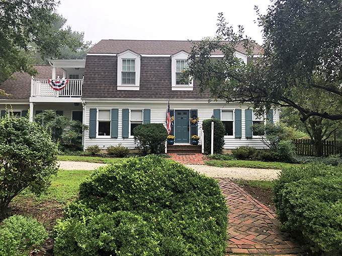 The Miller-Dunham House stands like a Norman Rockwell painting come to life, complete with sunlight filtering through mature trees and a welcoming brick patio.