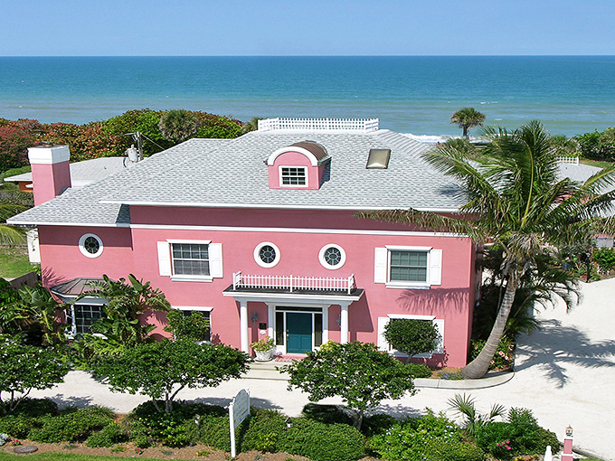 The coral-pink fa&ccedil;ade of Windermere Inn by the Sea stands like a blushing debutante against Florida's blue sky, promising coastal comfort with every white-trimmed window.