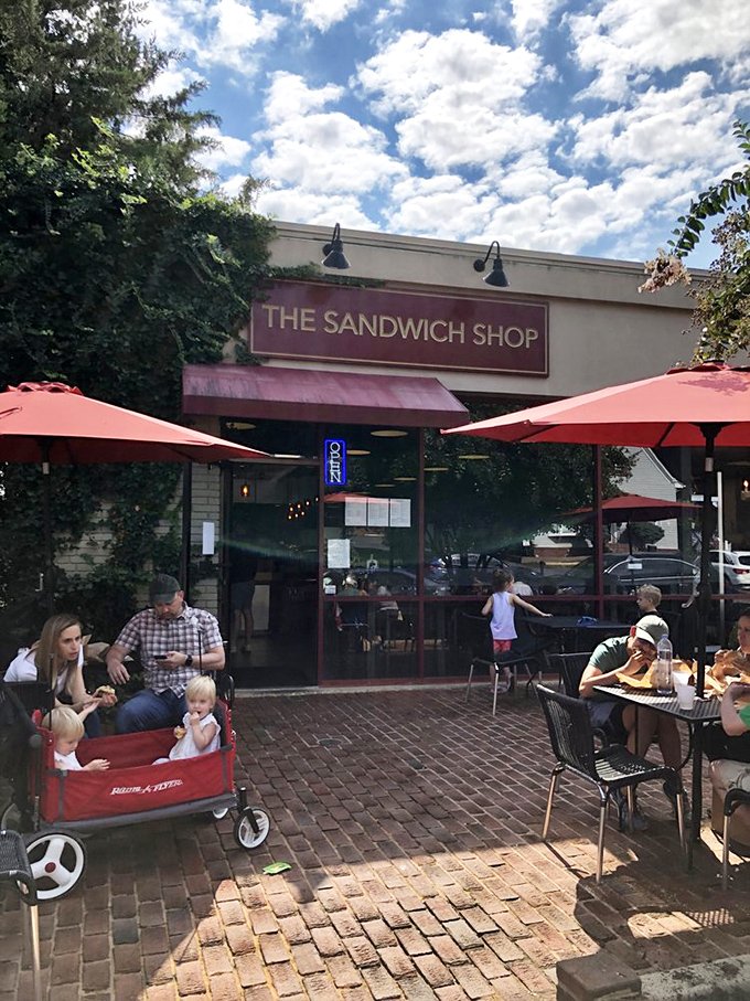 The red-framed storefront of The Sandwich Shop beckons like a beacon of lunch salvation, complete with charming brick patio seating under Vienna's leafy canopy.
