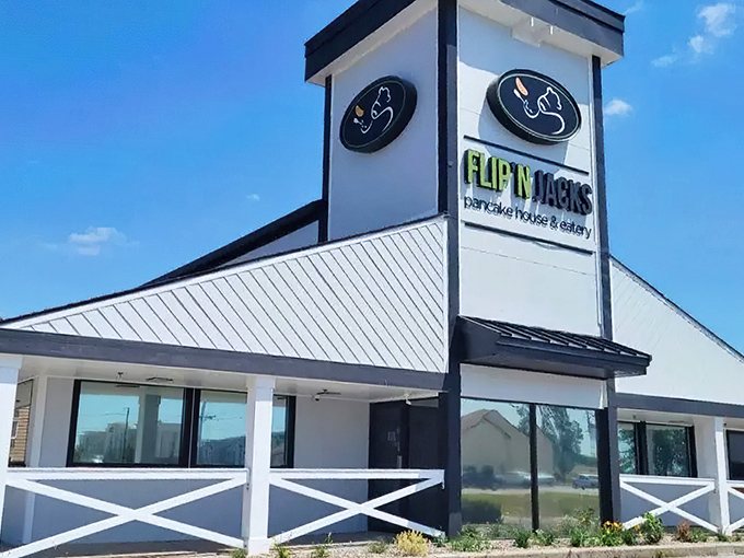 The distinctive peaked roof and farmhouse-style railing of Flip'N Jacks stands like a breakfast beacon in Ames, promising pancake paradise within.