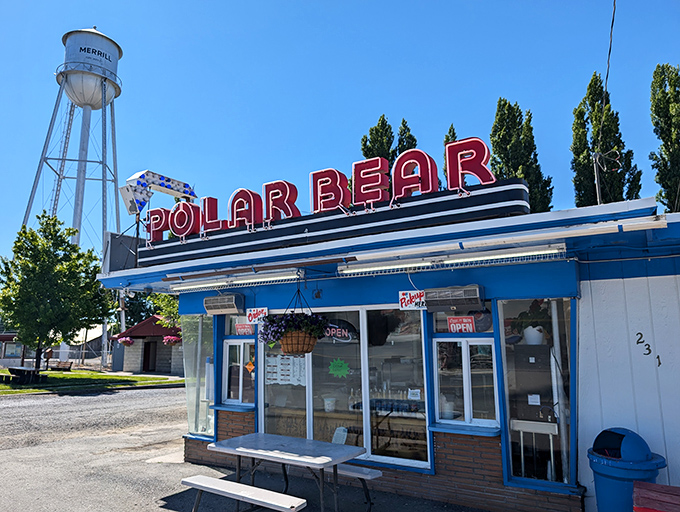 The iconic Polar Bear stands proudly against Merrill's water tower, its vintage neon sign promising cold treats in a warm welcome.