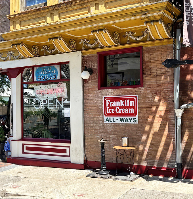 The storefront beckons like a time portal to ice cream's golden age&mdash;ornate yellow cornice, classic signage, and that brick facade promising sweet nostalgia inside.