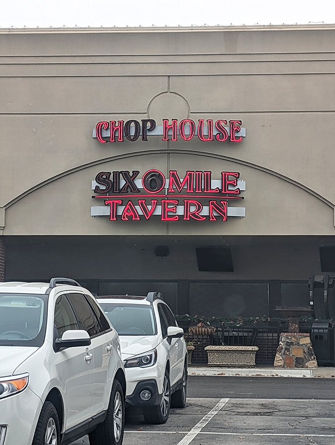 The neon sign of Six Mile Chop House beckons like a carnivore's lighthouse, promising safe harbor for the steak-obsessed traveler in Lawrence.