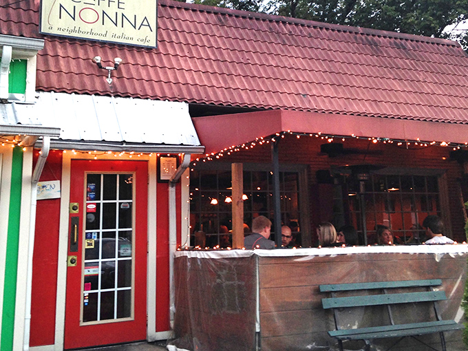 The red door to pasta paradise beckons from beneath a terracotta roof, promising Italian comfort in Nashville's Sylvan Park neighborhood.