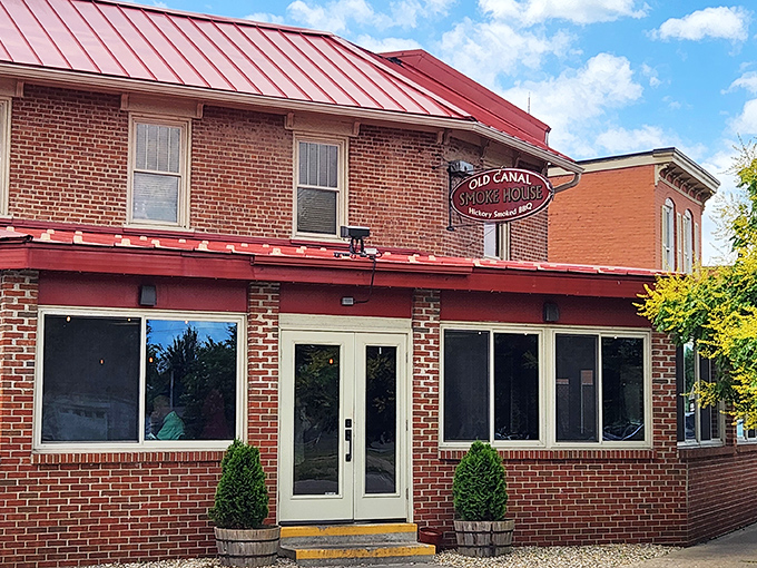 The historic brick exterior of Old Canal Smoke House welcomes you with its charming red awning and flower boxes&mdash;like a barbecue beacon calling you home.