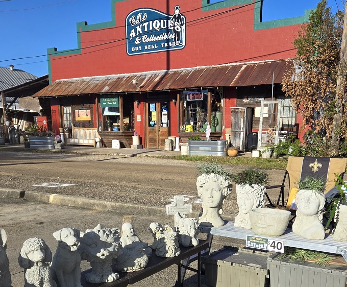 The vibrant red facade of C.J.'s Antiques & Collectibles stands out like a beacon for treasure hunters, promising adventures in nostalgia beneath that rustic metal roof.