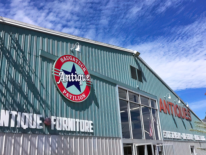The mint-green exterior of Saugatuck Antique Pavilion stands proudly against a blue Michigan sky, with a classic convertible parked out front&mdash;nostalgia in architectural and automotive form.
