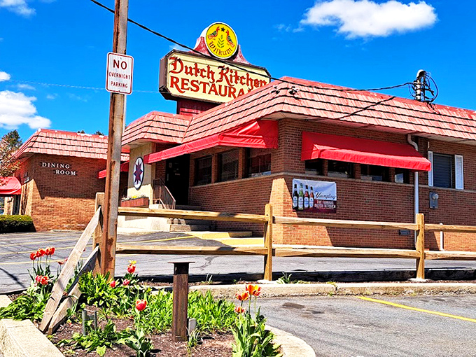 The iconic red-roofed Dutch Kitchen stands like a beacon of comfort food promise, complete with spring tulips that seem to bow in culinary reverence. 
