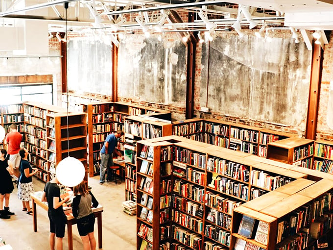 The Dusty Bookshelf's labyrinth of wooden shelves and industrial-chic walls creates a literary treasure hunt where stories wait to be discovered.