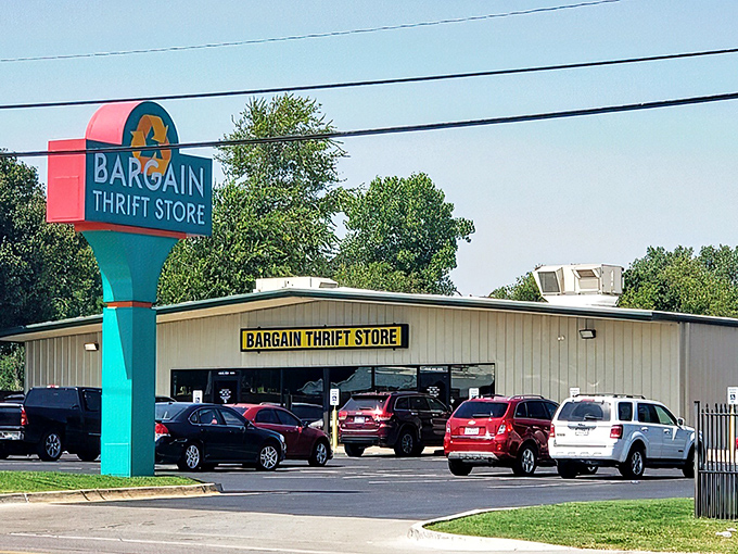 The unassuming exterior of Bargain Thrift Store stands like a vault of hidden treasures, its yellow sign a beacon to bargain hunters across Oklahoma City.
