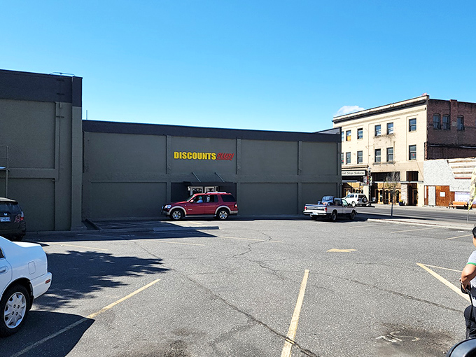 The bright yellow and red Discounts Plus sign beckons like a lighthouse for bargain hunters navigating the sea of retail prices.