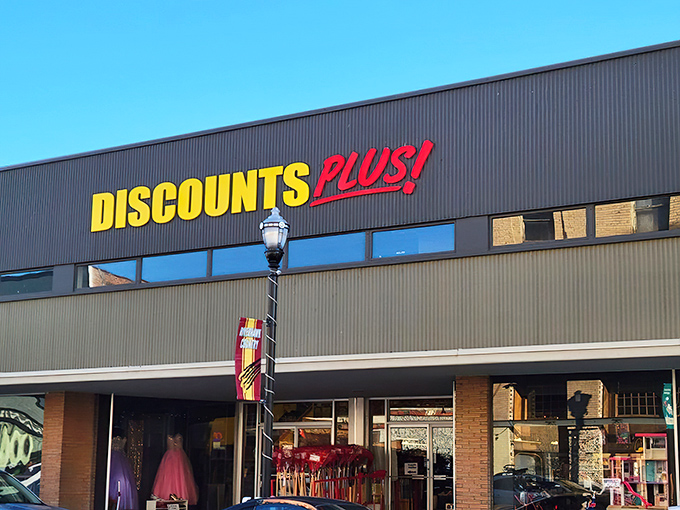 The bright yellow and red Discounts Plus sign beckons like a lighthouse for bargain hunters navigating the sea of retail prices.