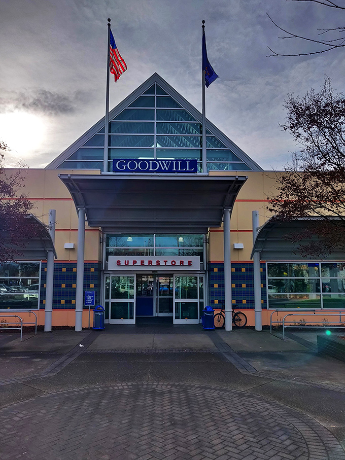 The iconic triangular entrance to Goodwill's Portland superstore stands like a beacon for treasure hunters, promising adventures in secondhand shopping beneath those blue letters. 
