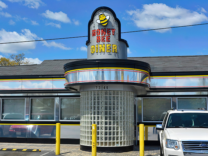 The classic mid-century diner silhouette of Honey Bee stands proud against the Maryland sky, its cheerful bee mascot promising sweet culinary delights within.