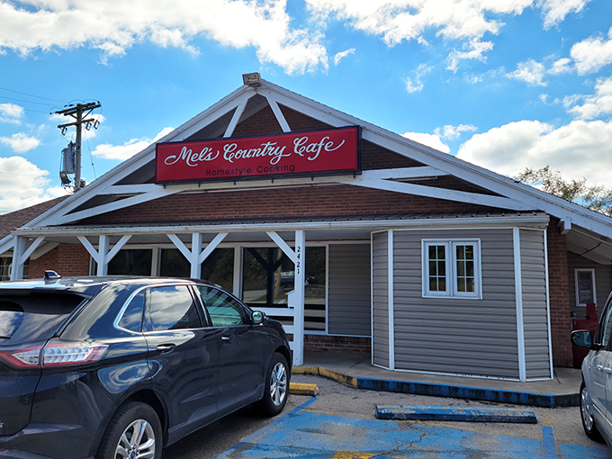 The unassuming exterior of Mel's Country Cafe sits like a red-signed promise of comfort food bliss under Missouri skies.