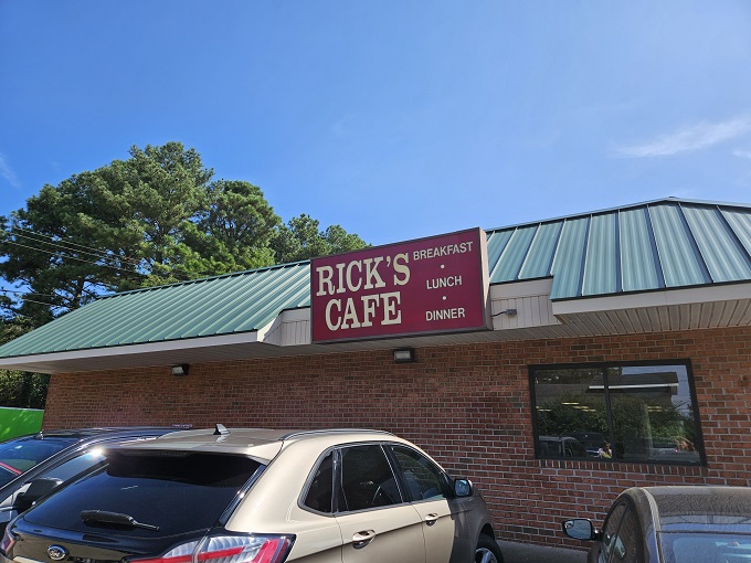 Welcome to Rick's Cafe, where the green roof and red sign beckon like a lighthouse for hungry souls. This unassuming exterior hides a treasure trove of comfort food delights!