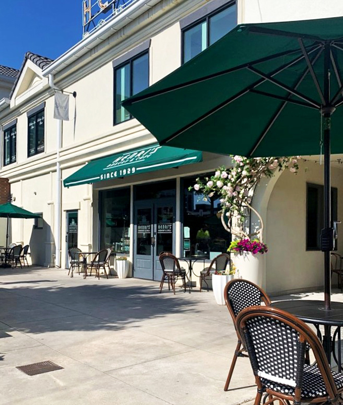 A little slice of heaven with green umbrellas providing shade as diners enjoy their meal on Henri's inviting outdoor patio. The perfect urban oasis.