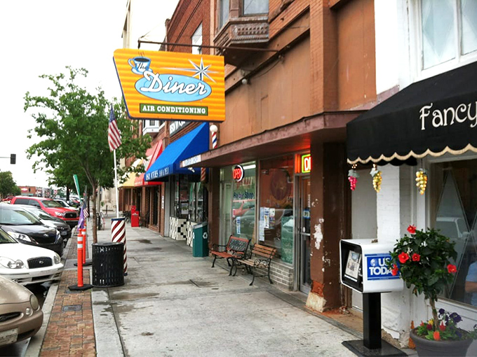 The Diner's vintage neon sign promises "AIR CONDITIONING" like it's 1955, a glowing beacon of breakfast hope on Norman's Main Street.