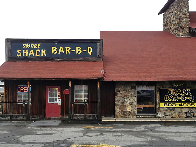 That hand-painted yellow sign against weathered wood isn't just decoration&mdash;it's a promise of smoky delights waiting behind that bright red door.