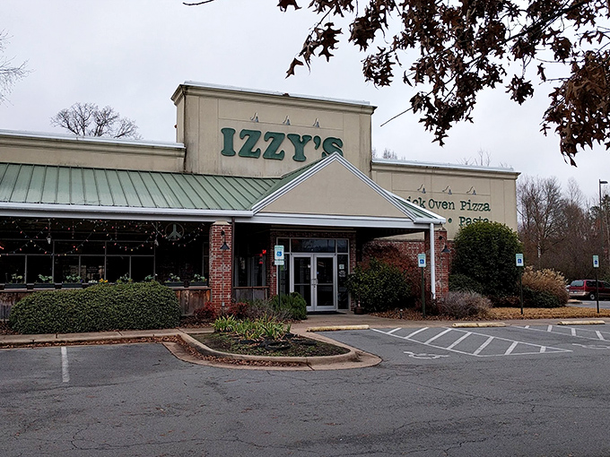 Izzy's welcomes hungry travelers with its distinctive green-trimmed roof and promise of brick oven delights—like finding a culinary oasis in Little Rock.