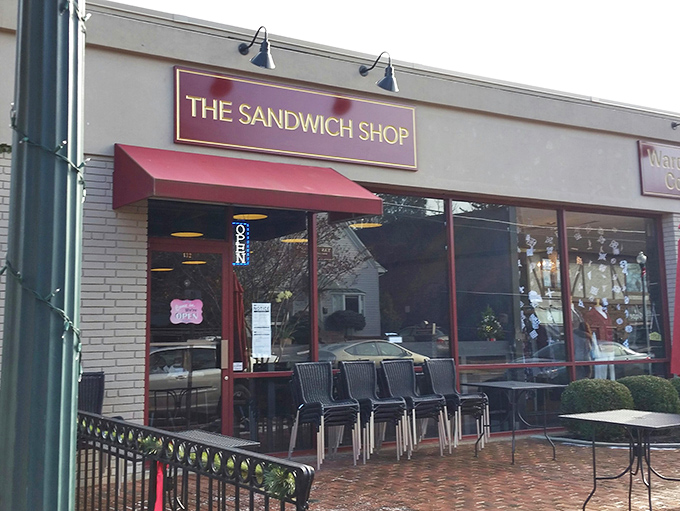 The red-framed storefront of The Sandwich Shop beckons like a beacon of lunch salvation, complete with charming brick patio seating under Vienna's sky.