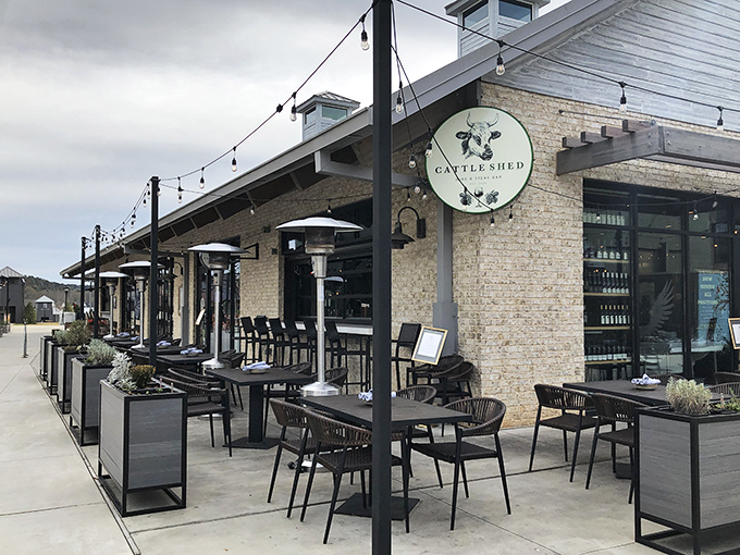 Modern farmhouse meets culinary playground at Cattle Shed's inviting exterior. String lights and comfortable outdoor seating promise evenings of beef-centric bliss in Alpharetta.