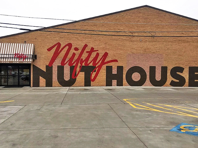 The brick facade of Nifty Nut House stands like a temple to temptation, its bold red script promising sweet adventures within. 