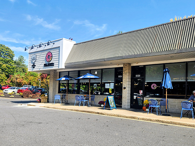 The pink donut sign beckons like a sugar-dusted lighthouse, guiding hungry travelers to this unassuming strip mall treasure in Wilmington.