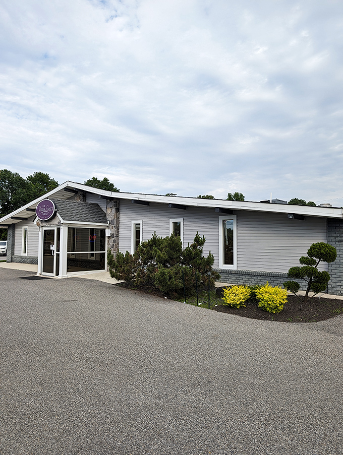 The neon pink sign glows like a beacon in the night, promising culinary treasures inside this unassuming roadside building.
