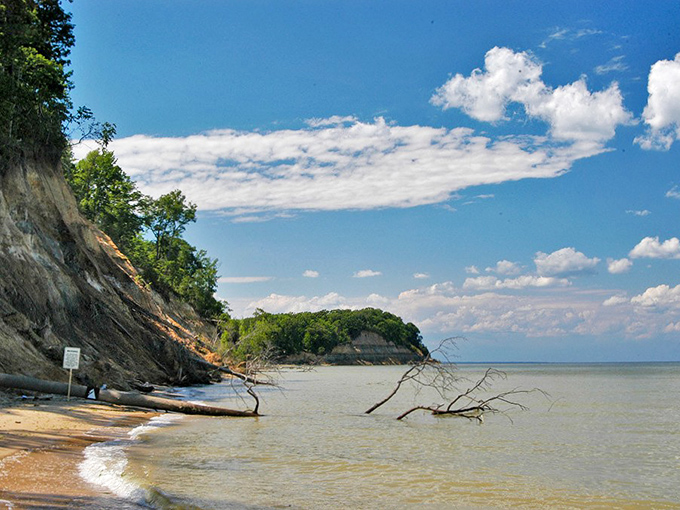Nature's own sculpture gallery where towering cliffs meet gentle waves, creating a beach experience that's part geological wonder, part treasure hunt.