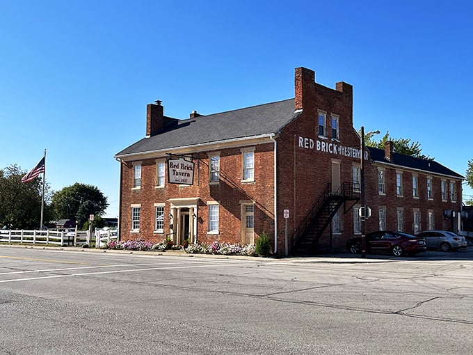 The historic facade of Red Brick Tavern stands proudly along Route 40, its weathered bricks whispering stories from nearly two centuries of serving hungry travelers.